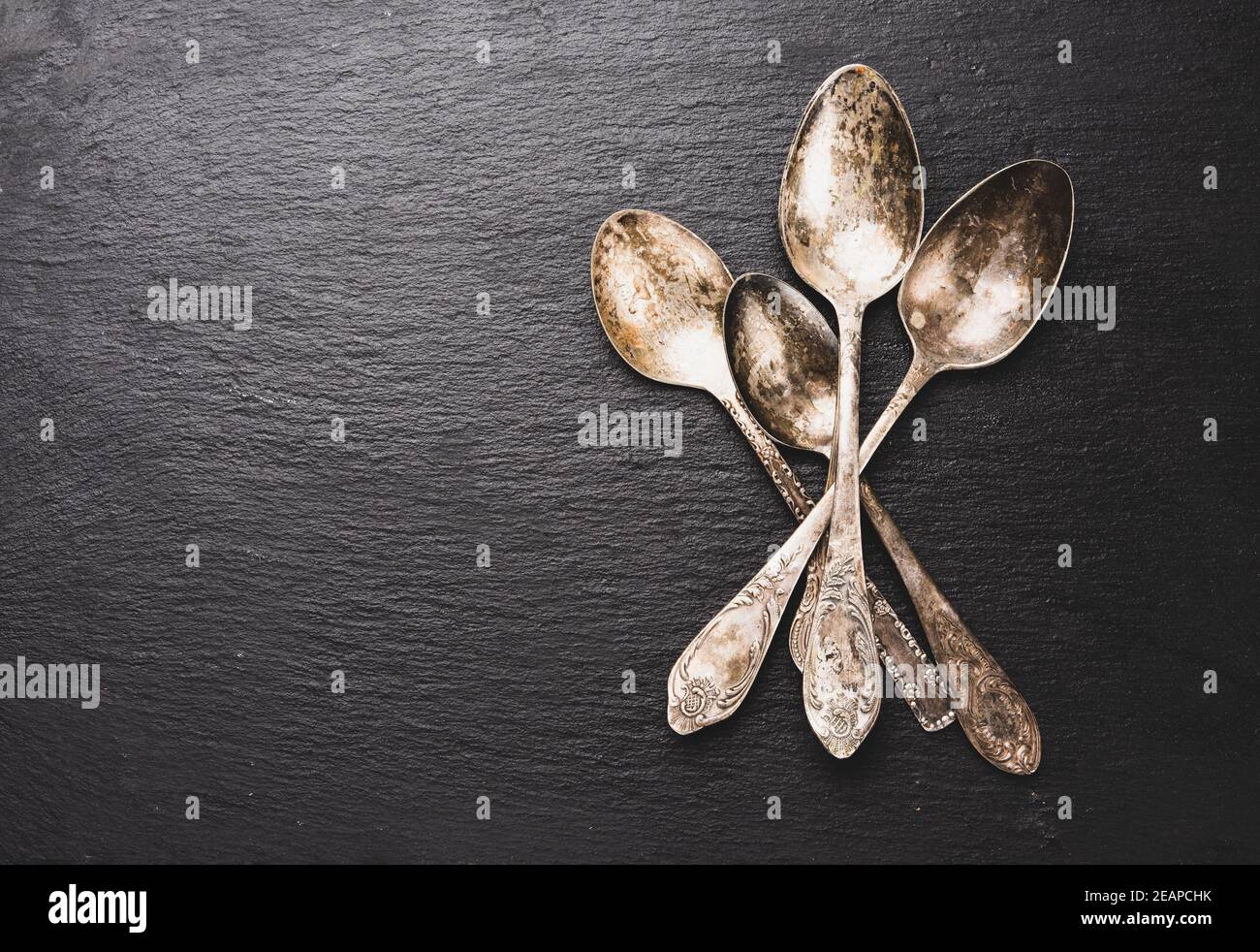 vintage metal empty spoons on black graphite background, top view Stock ...