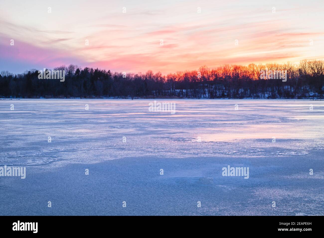 Snow covered lake reflecting colors of sunset in winter Stock Photo - Alamy