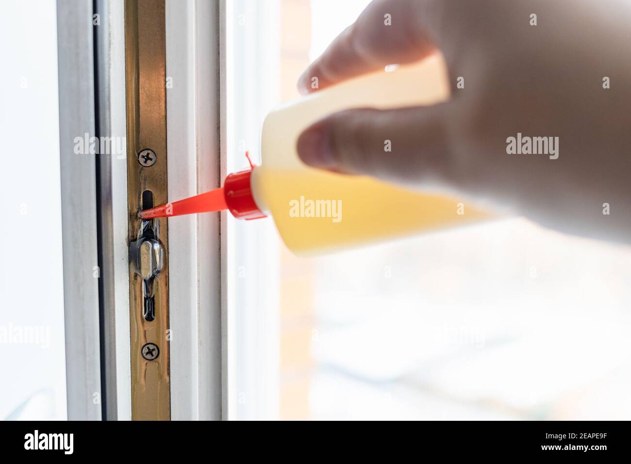 lubricating window frame mechanism with oil f Stock Photo - Alamy
