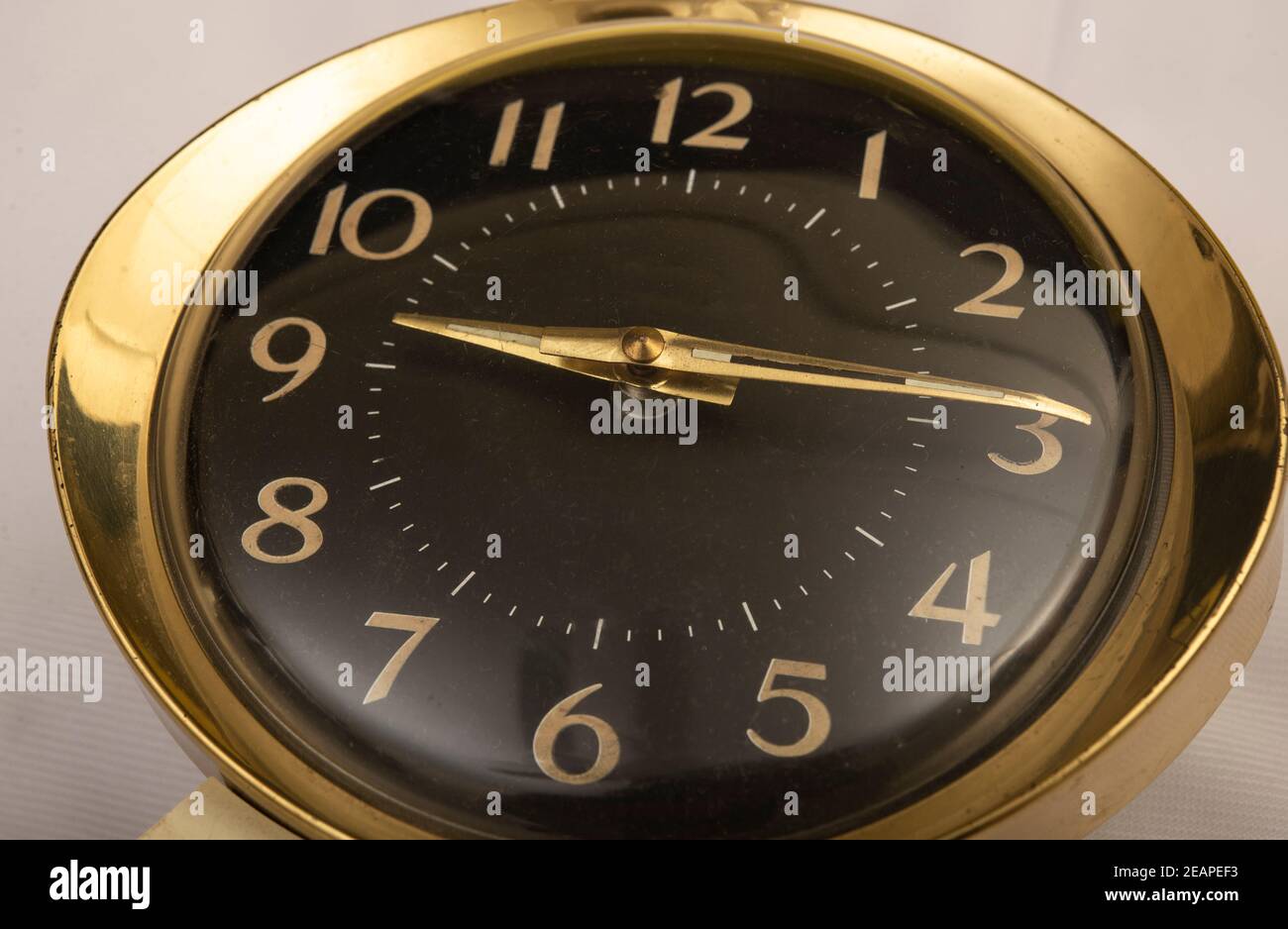 Gold color table clock showing 9 o clock time closeup Stock Photo - Alamy