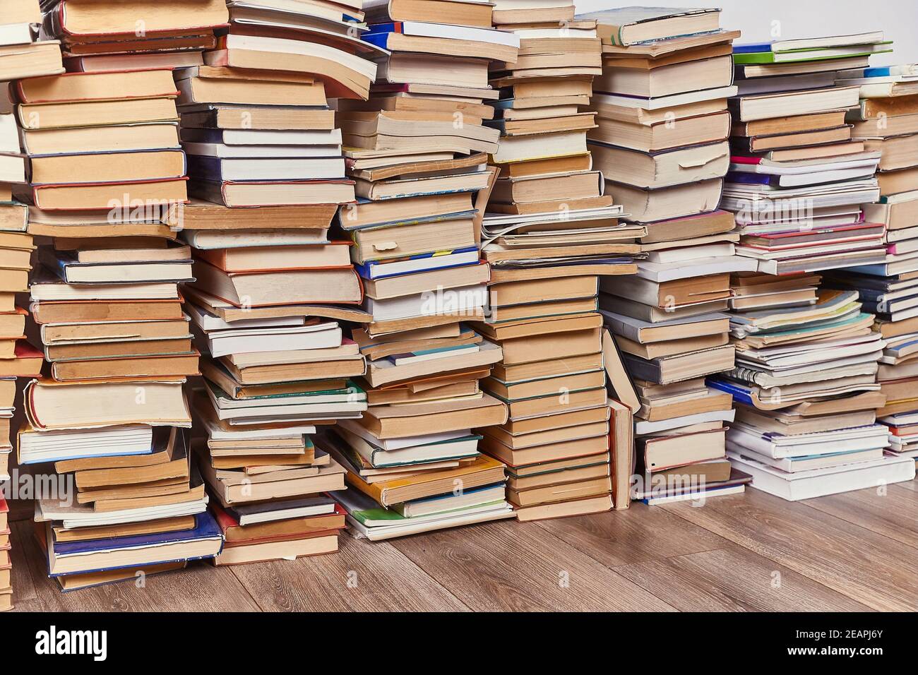 Wall of books piled up Stock Photo - Alamy