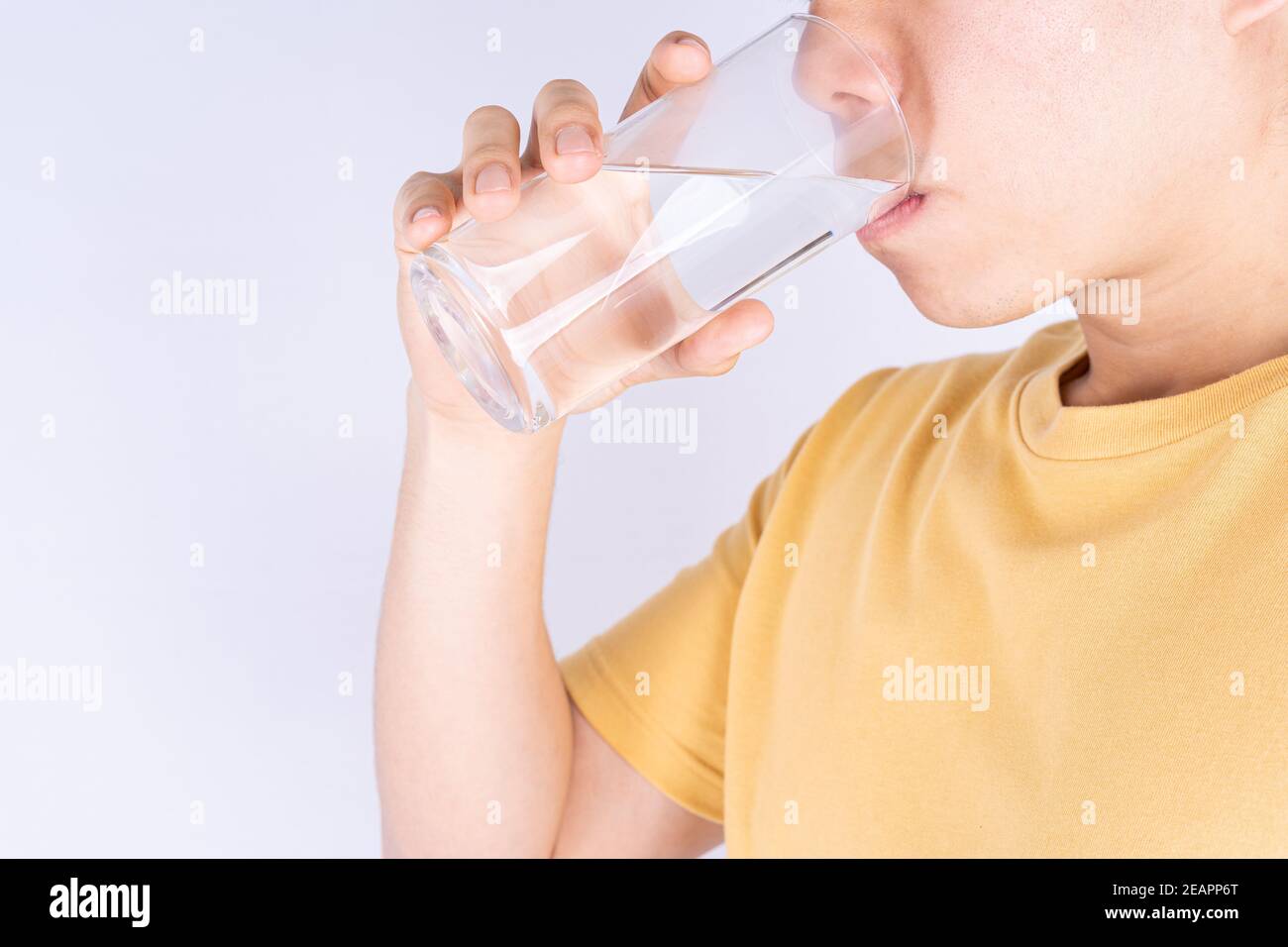 Man drinking water isolated grey background. Clean drinking water in clear glass Stock Photo - Alamy