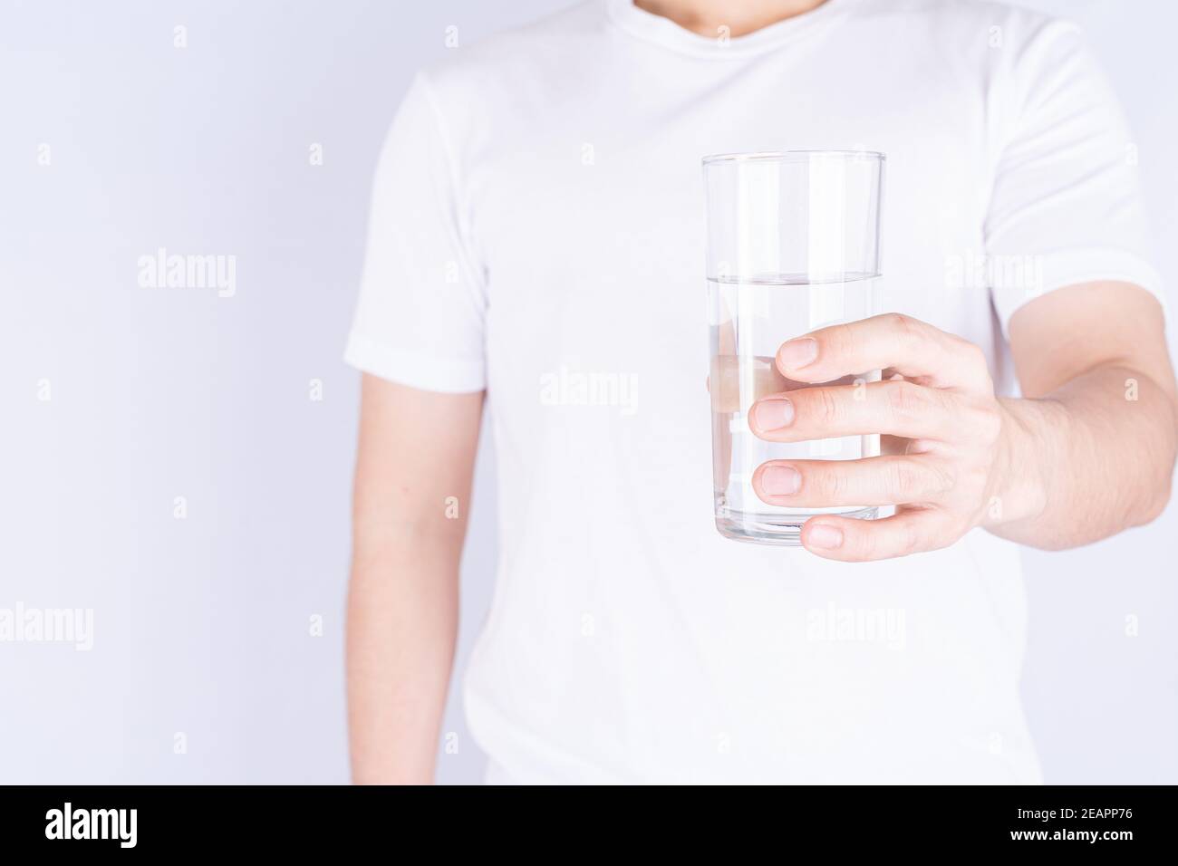 Man holding glass of water isolated grey background. Clean drinking water in clear glass Stock ...