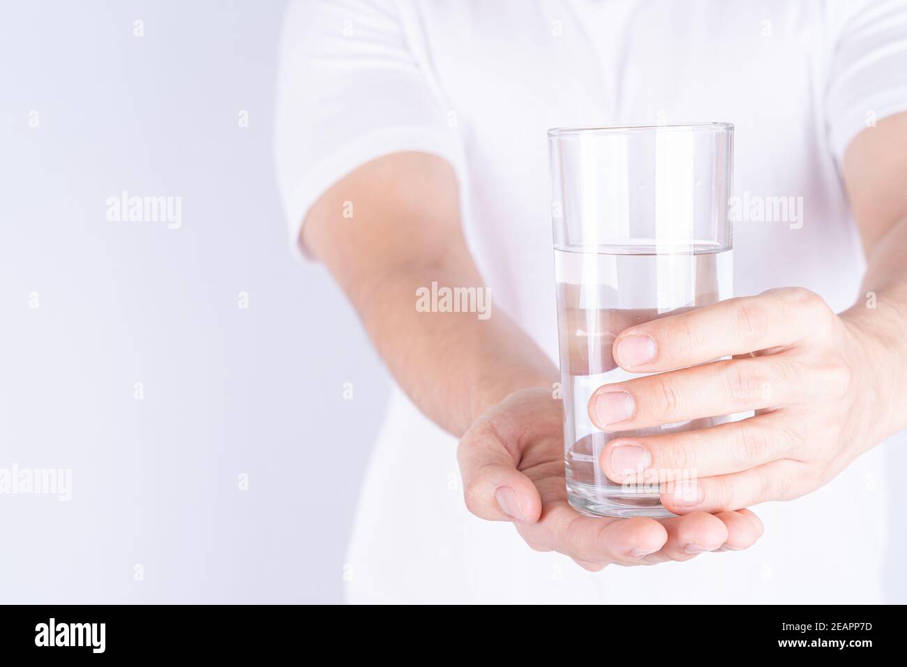 Man holding glass of water isolated grey background. Clean drinking water in clear glass Stock ...