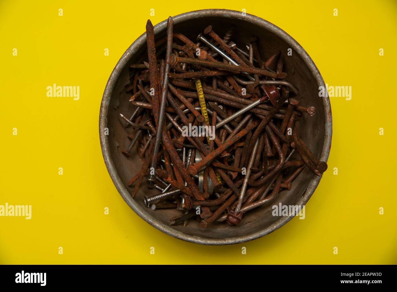 metal rusty nails on a yellow background Stock Photo - Alamy