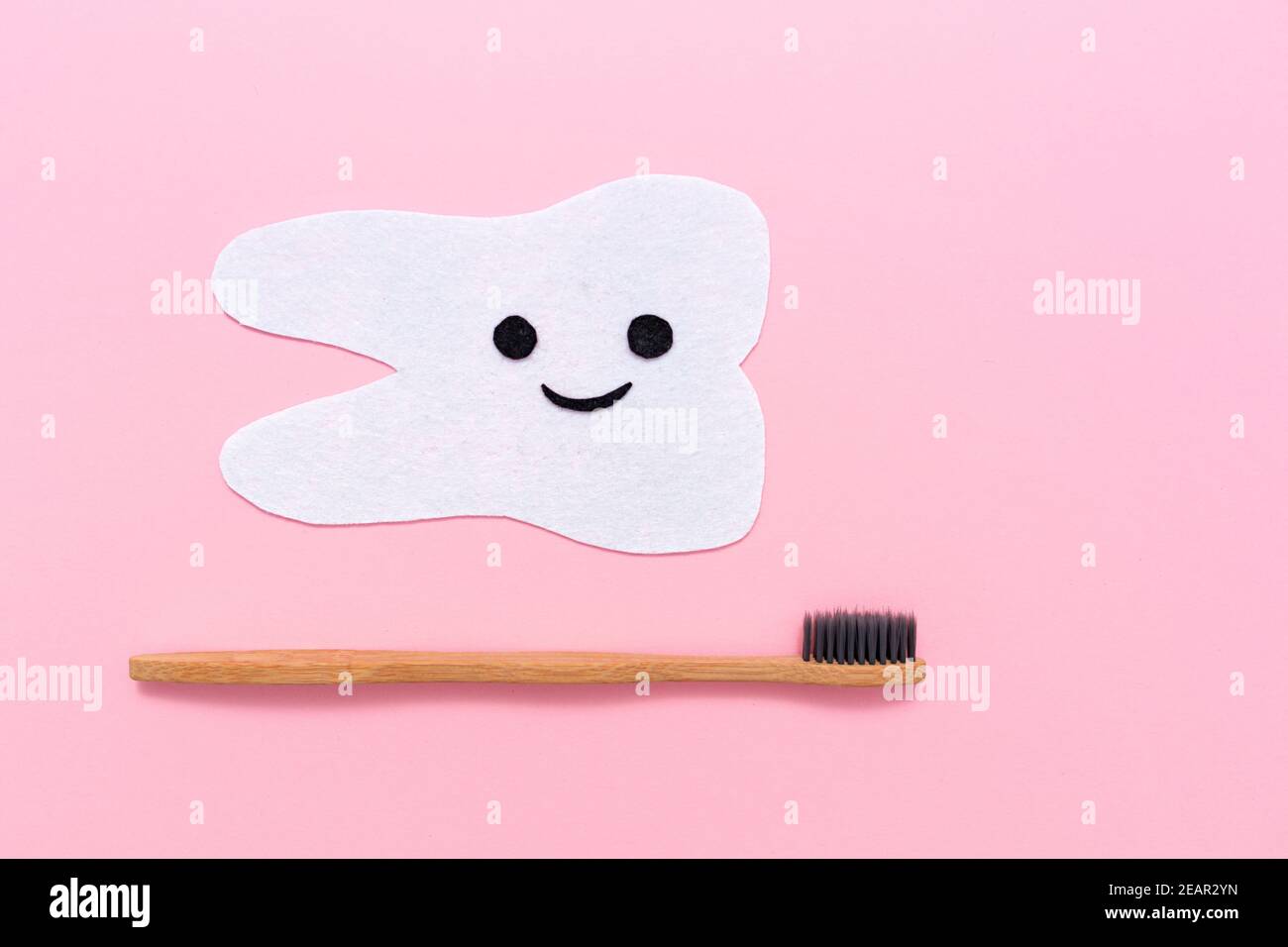 Cut out tooth of felt with cartoon smile and bamboo toothbrush. Pink ...