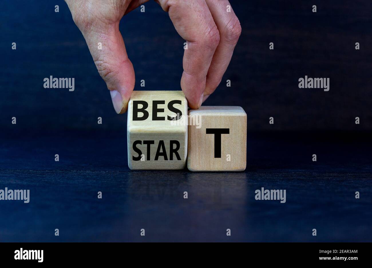Time to best start symbol. Businessman turns a wooden cube with words ...