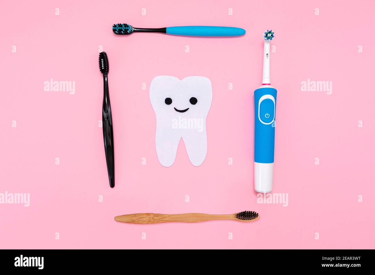 A frame of different toothbrushes surrounding a smiling tooth carved ...