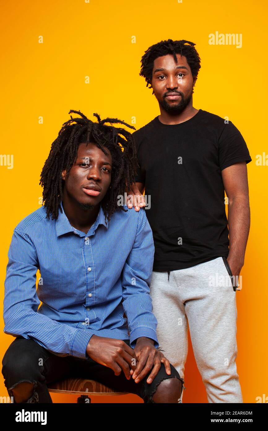 two african american guys posing cheerful together on yellow background ...