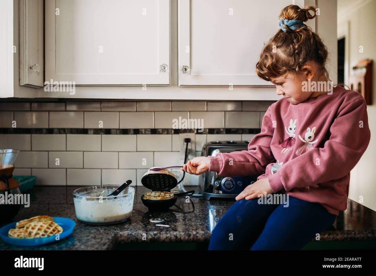 Young girl checking waffle inside waffle maker for breakfast Stock ...