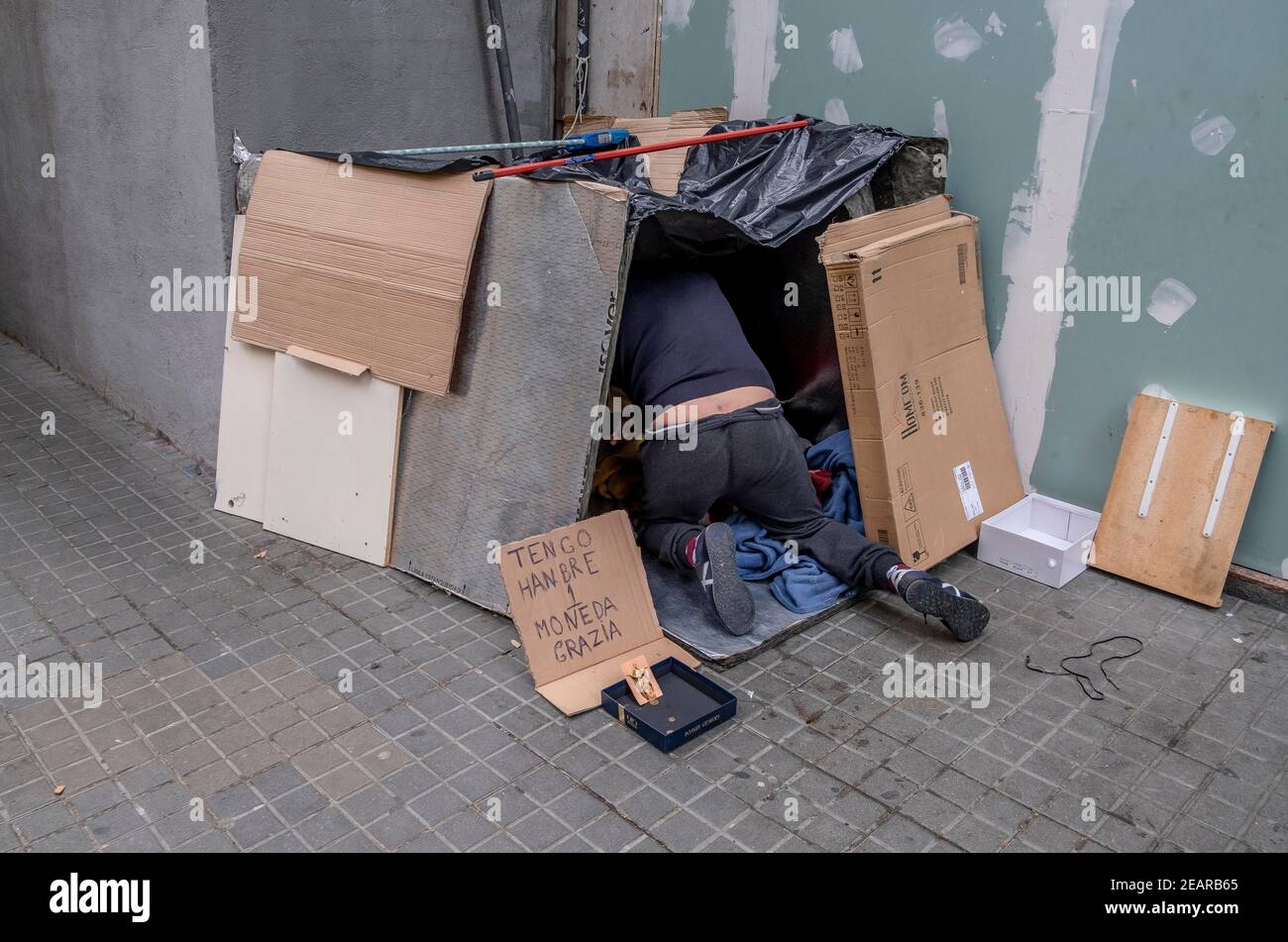 A homeless person is seen tidying up his shelter of cardboard boxes ...