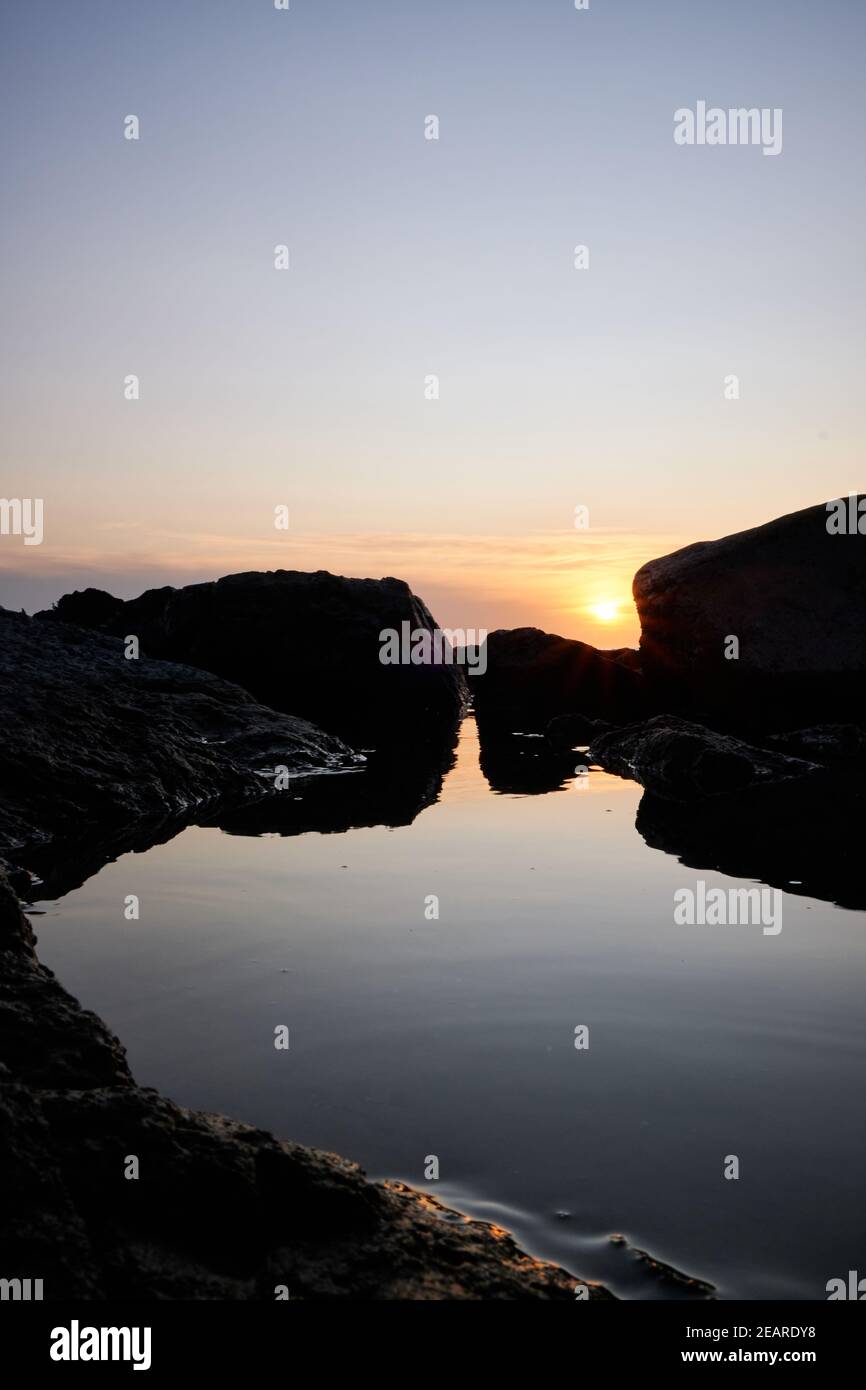 panoramic shot silhouette of sea stack rock formations at a golden ...
