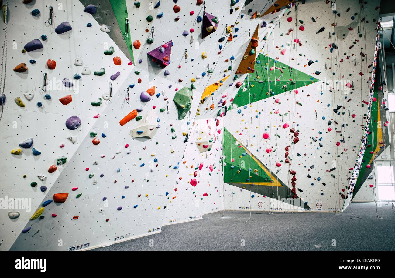 Climbing wall with holds and ropes Stock Photo - Alamy