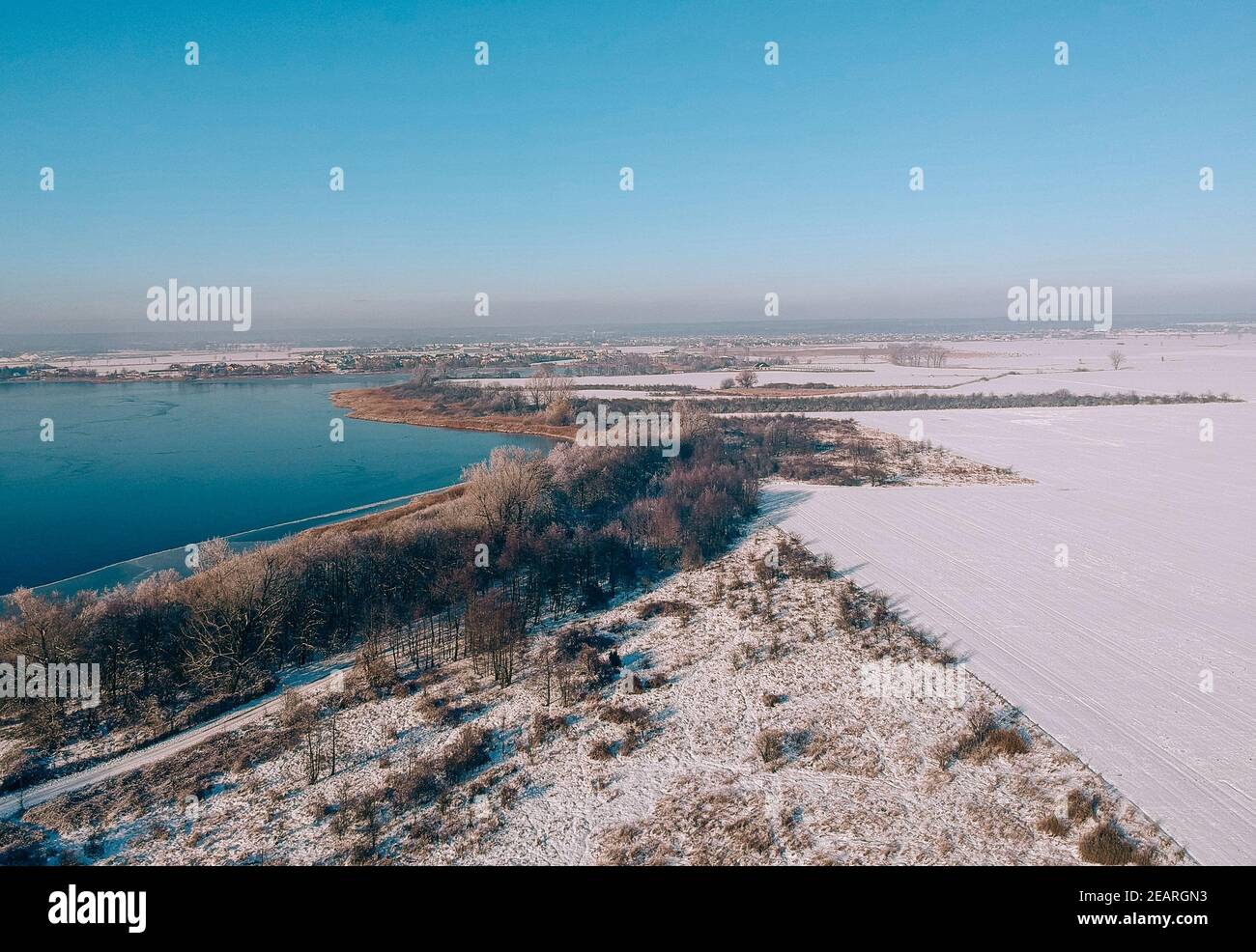 Aerial view of a lake near the land covered in deep snow Stock Photo ...