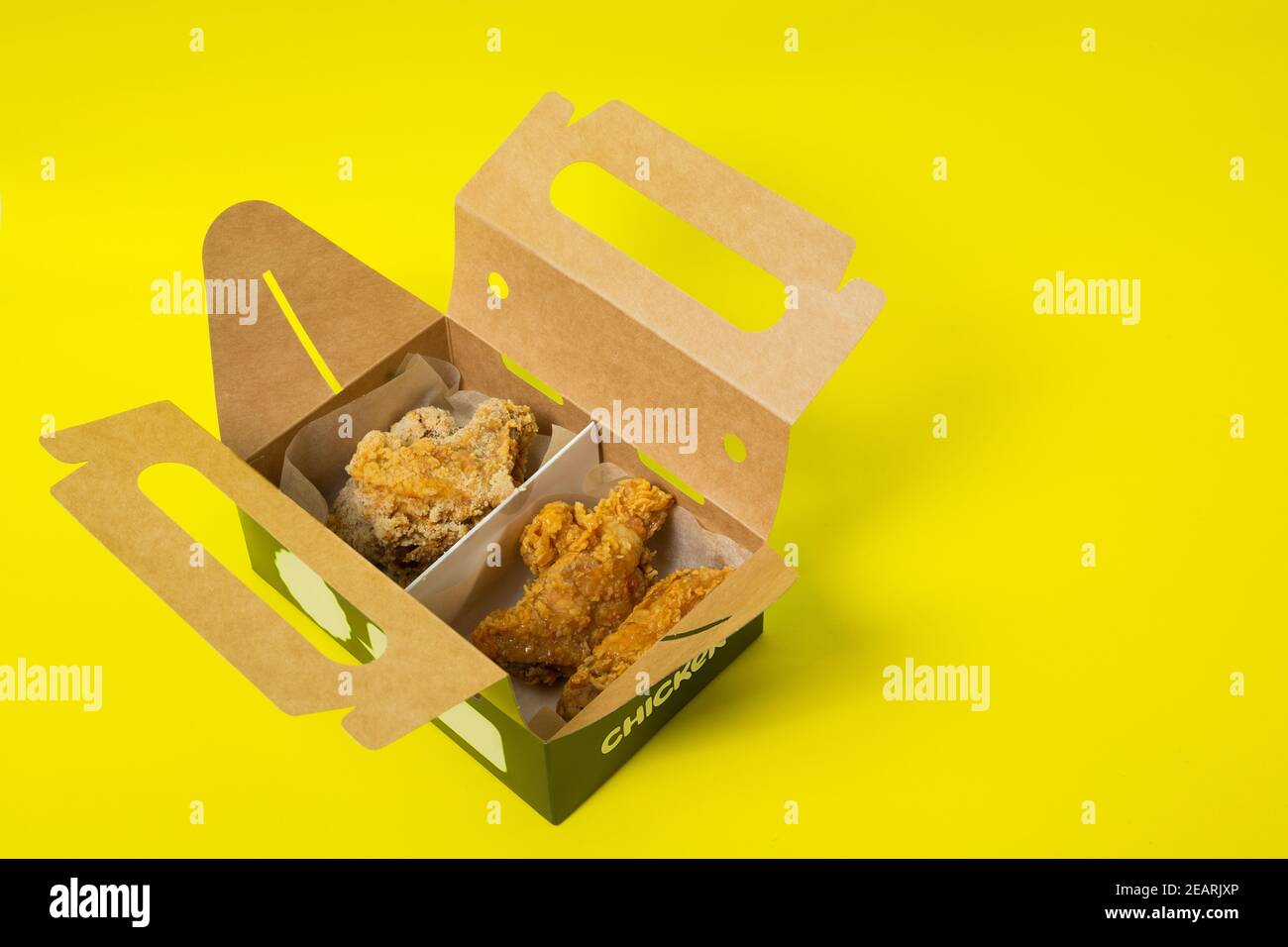 Chinese takeaway chicken with tomatoes, in a cardboard box photographed ...