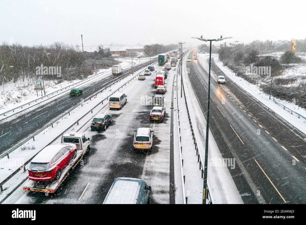 Traffic jam on two lanes during snow on a British dual carriageway, the ...