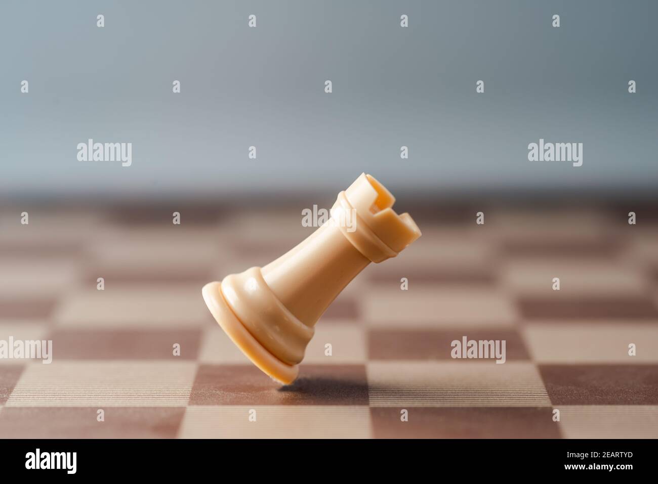 white chess castle falling on chess board concept of failing Stock ...