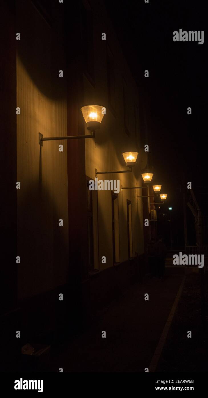 Yellow lamps on building shining at night Stock Photo - Alamy