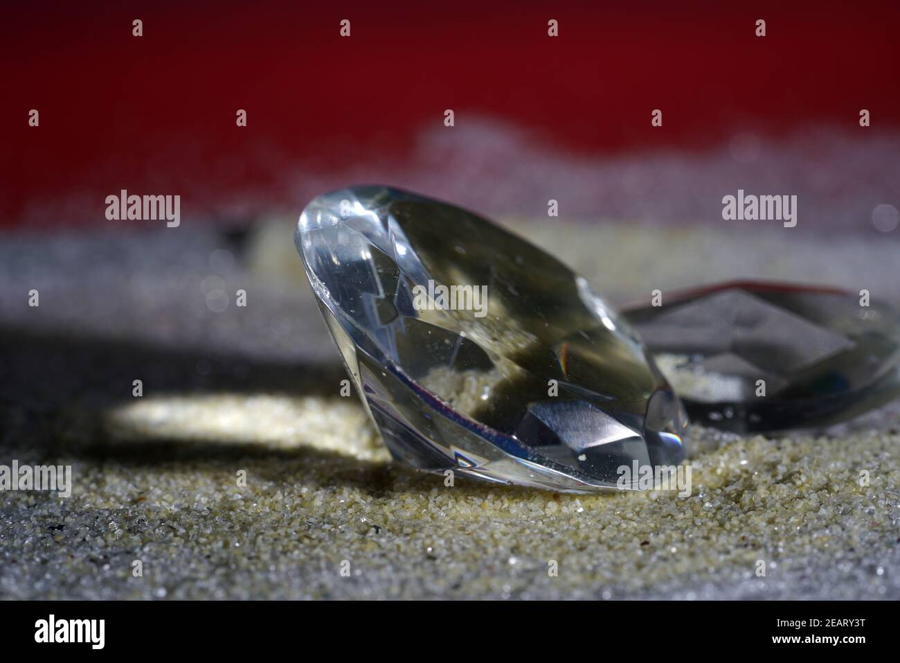 Closeup of artificial diamonds lying in the sand Stock Photo - Alamy