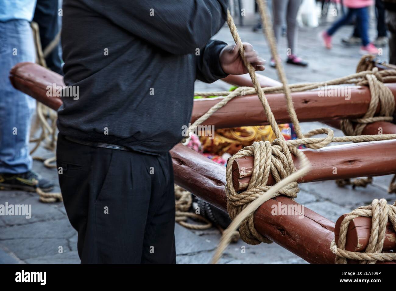 Man using ropes to secure a float, Corpus Christi Celebration, Cusco ...