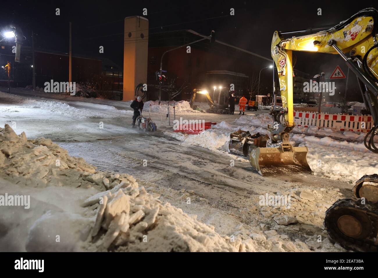 10 February 2021, Thuringia, Jena: Construction workers work at a road ...