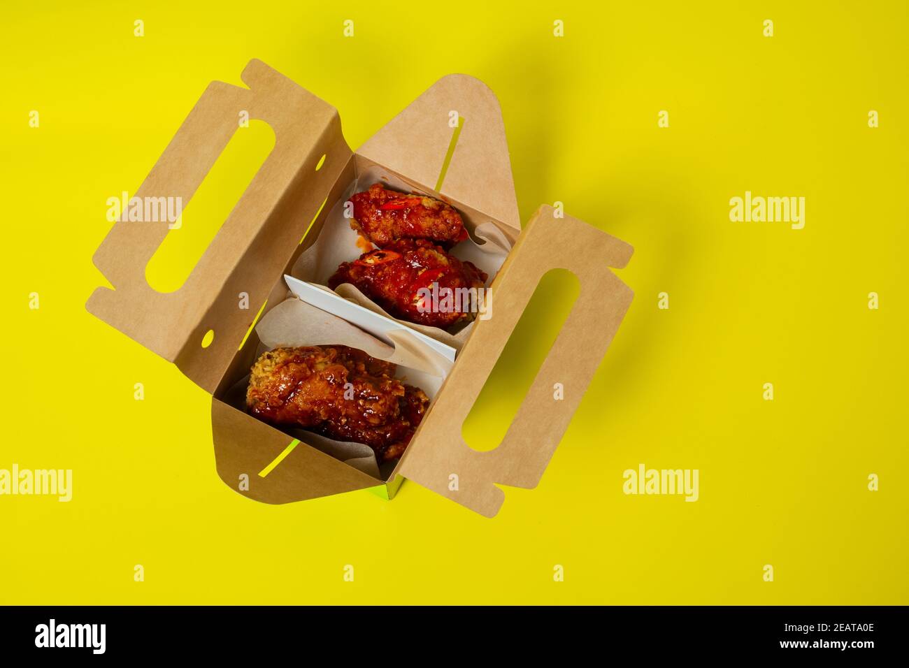 Chinese takeaway chicken with tomatoes, in a cardboard box photographed ...
