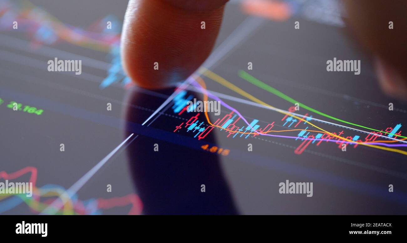 Finger touch on screen with stock market data Stock Photo - Alamy
