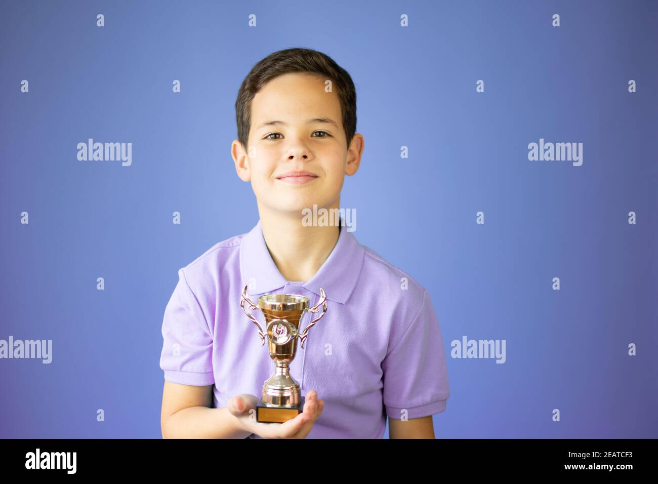 Young caucasian boy holding a trophy with celebrating pose Stock Photo ...