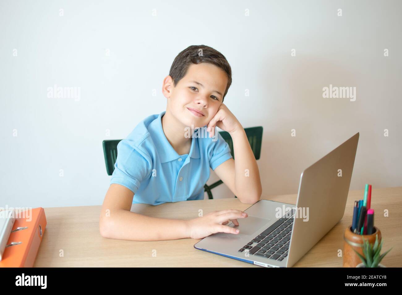 Young boy smiling and watching laptop in the classroom.A young boy ...