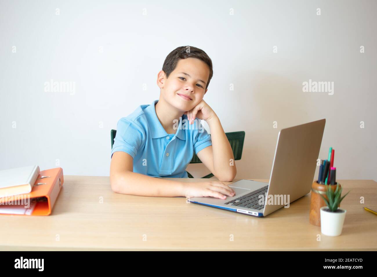 Young boy smiling and watching laptop in the classroom.A young boy ...