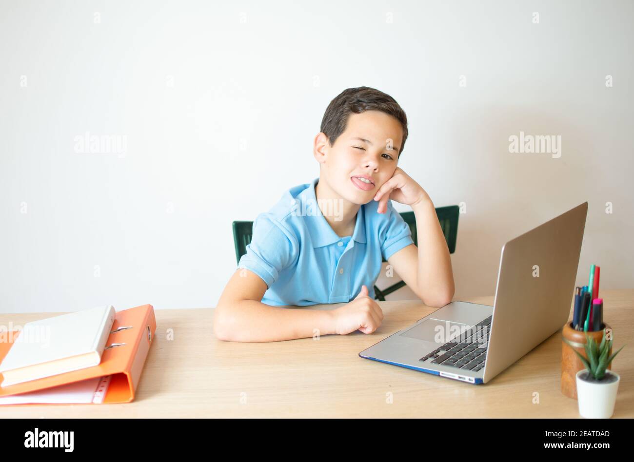 Young boy smiling and watching laptop in the classroom.A young boy ...