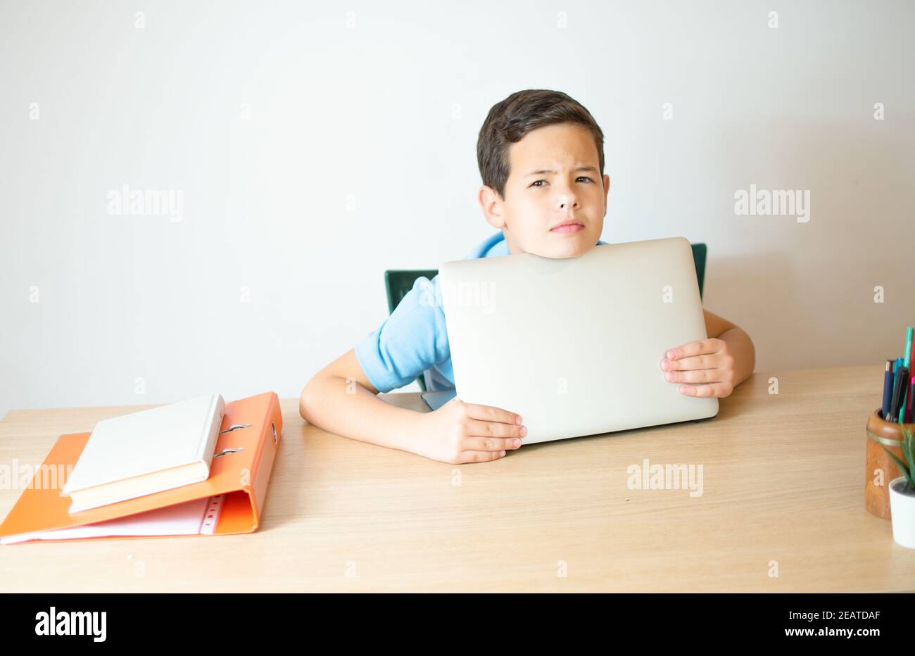 Young boy smiling and watching laptop in the classroom.A young boy ...