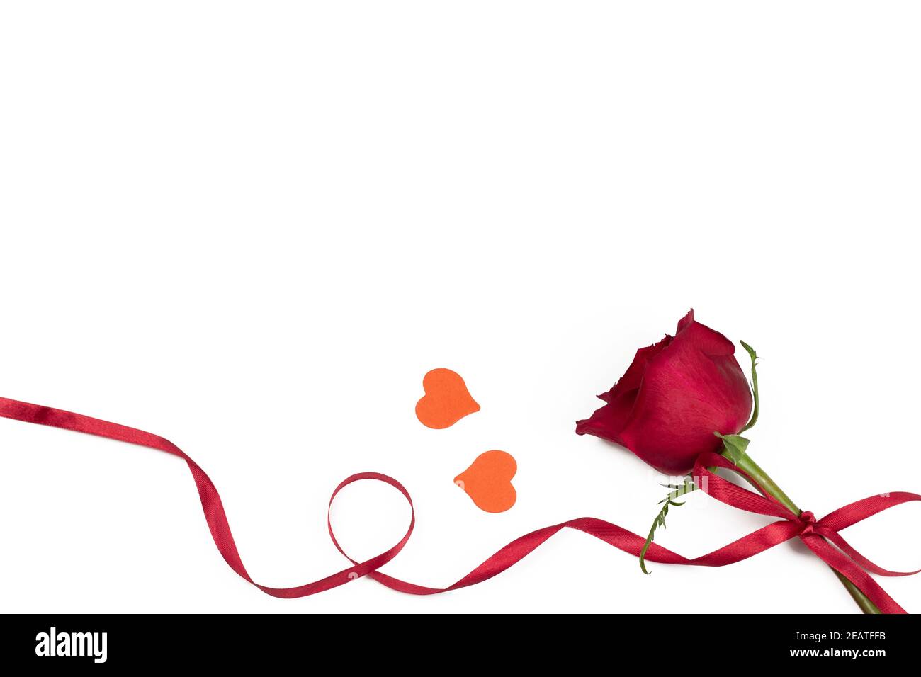 One red rose with red ribbon and little heart on white background ...
