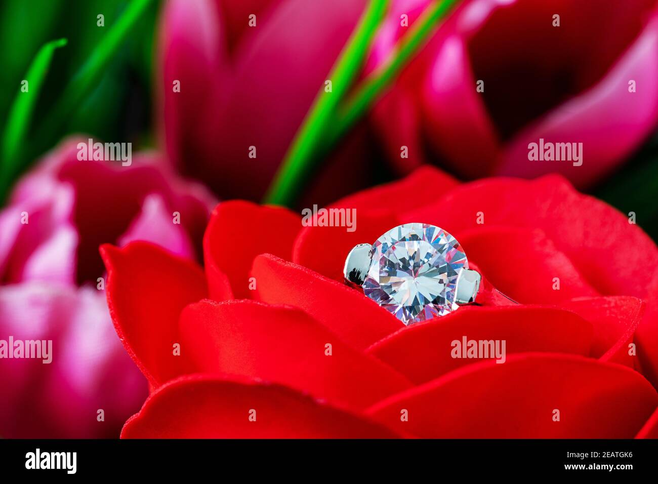 Diamond wedding rings on red roses Stock Photo - Alamy