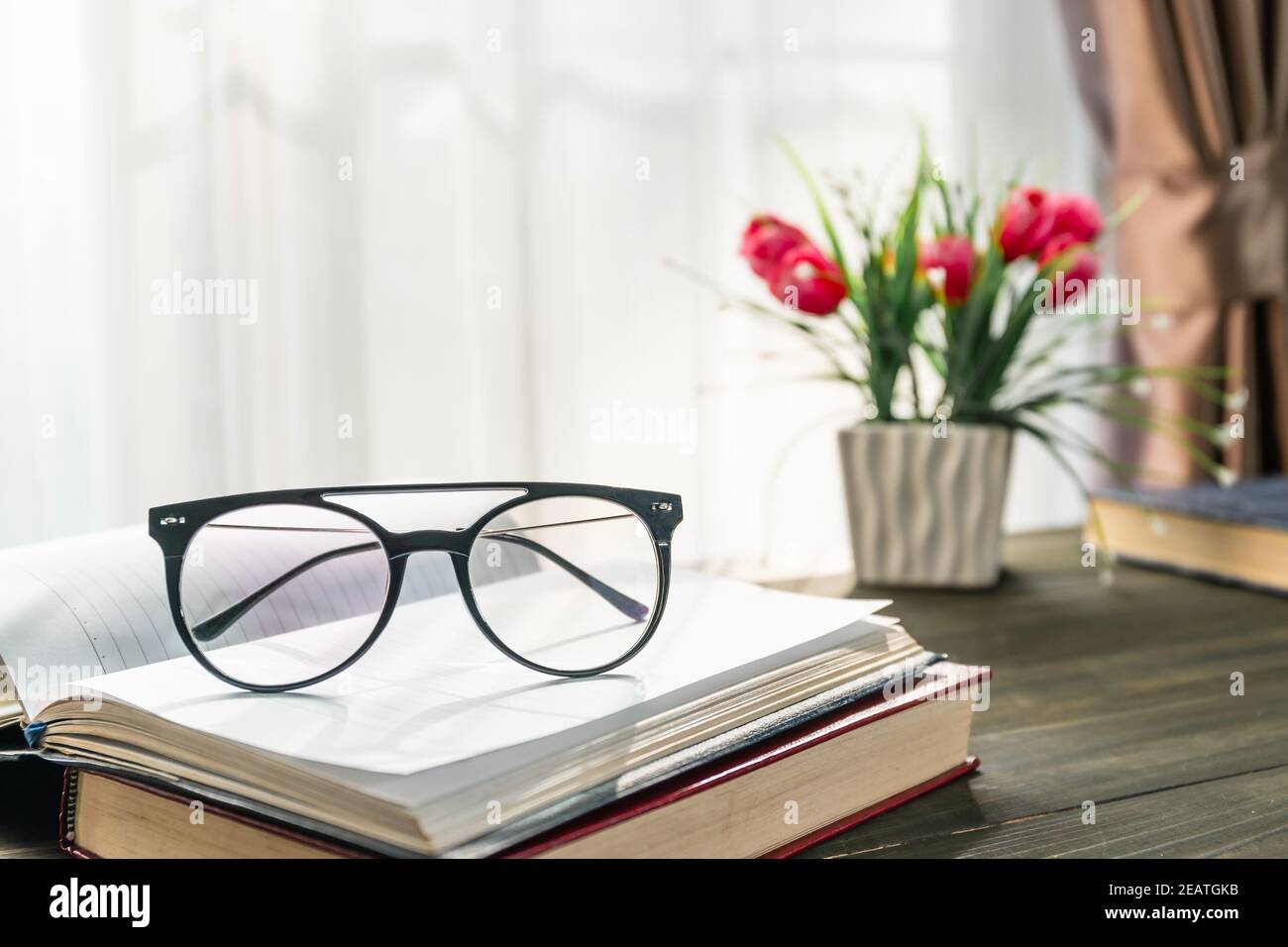 Reading glasses put on open book beside the window Stock Photo - Alamy