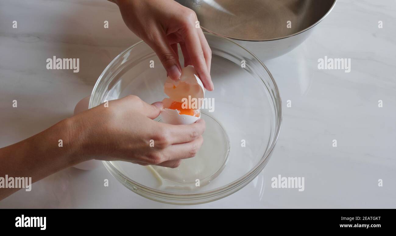 Break egg to separate egg white and yolk Stock Photo - Alamy