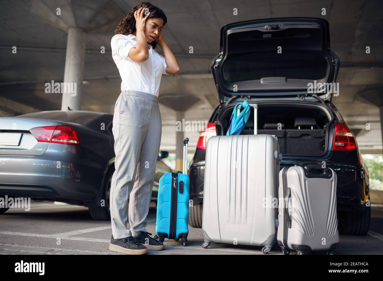 Young woman with suitcases in a panic, car parking Stock Photo - Alamy