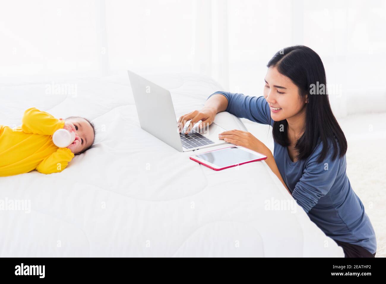 woman is working busy on laptop computer and tablet at home while her ...