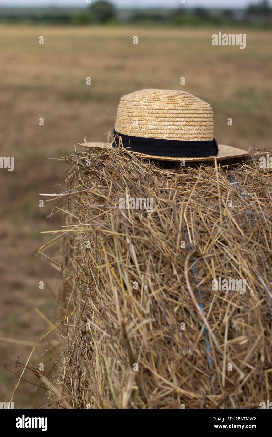 straw hat on a haystack in the field. summer background. rusting ...