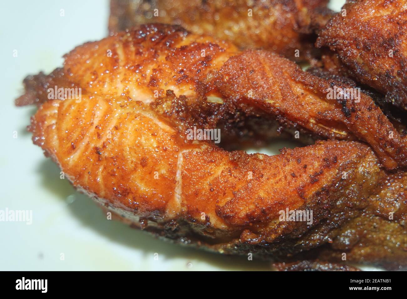 Spicy and crunchy barbecue of fried fish fillet on a white background ...