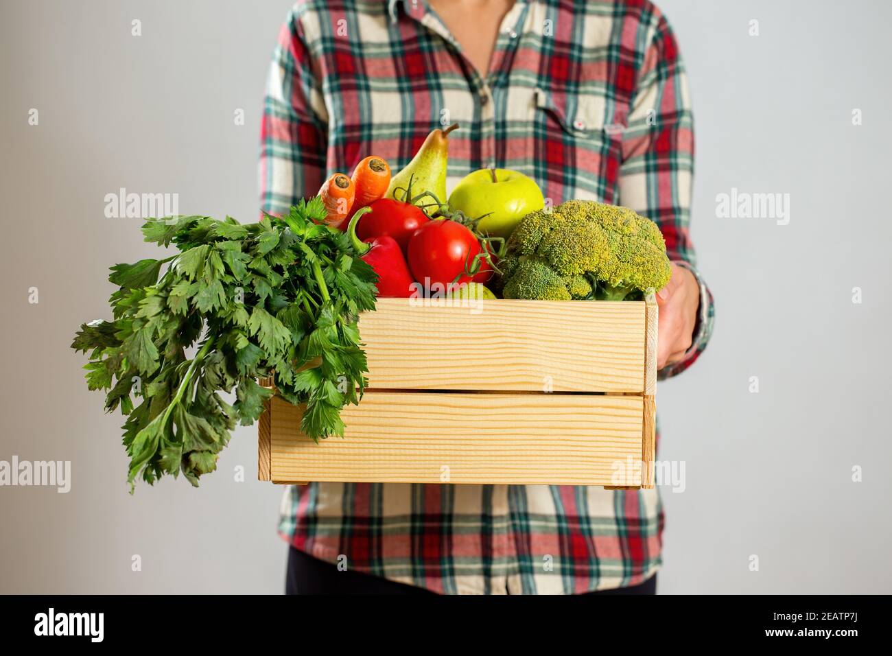Woman in flannel shirt holding box with fresh fruit and vegetable Stock ...