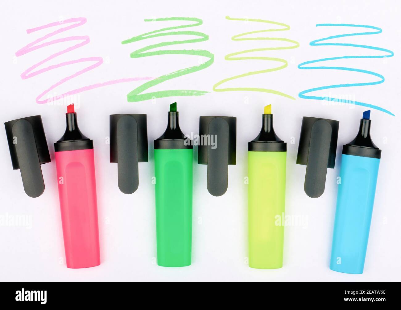 Four colorful markers and four drawn lines on a white sheet of paper ...