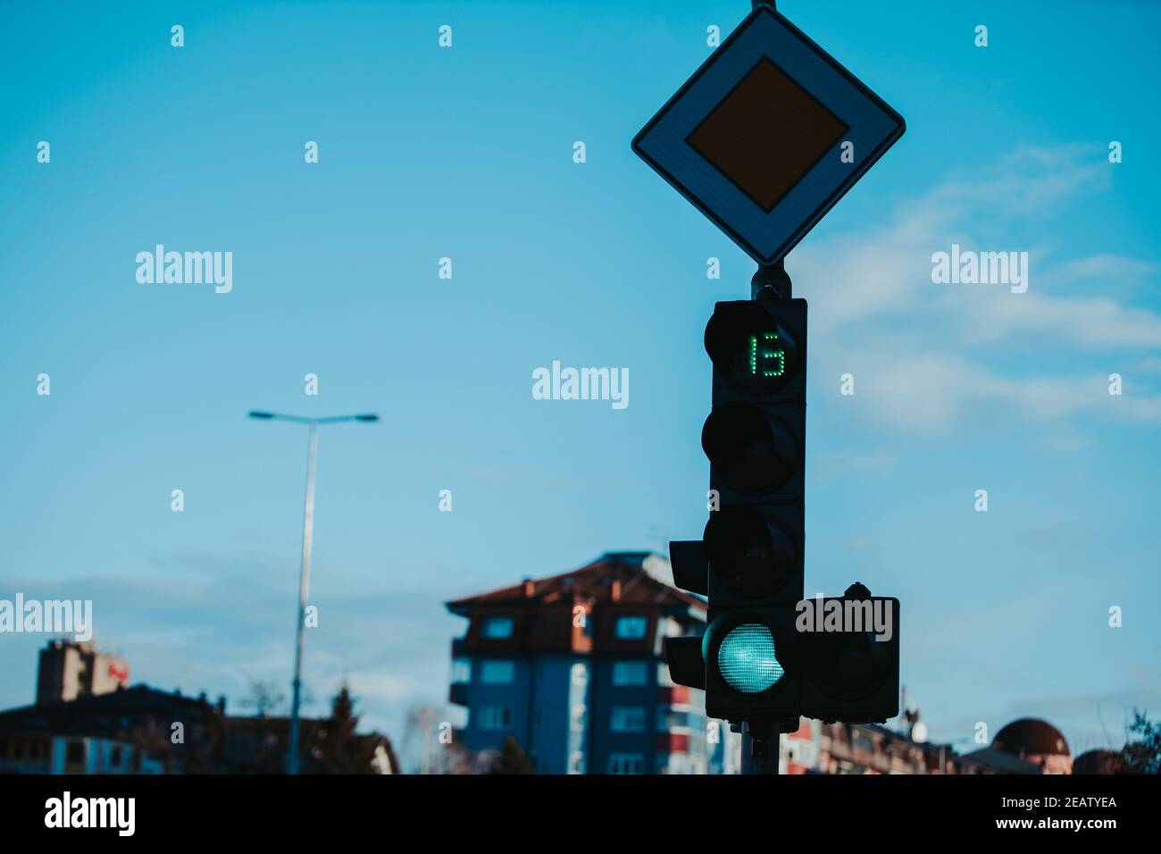 Main road sign and a traffic light on blue sky background Stock Photo ...