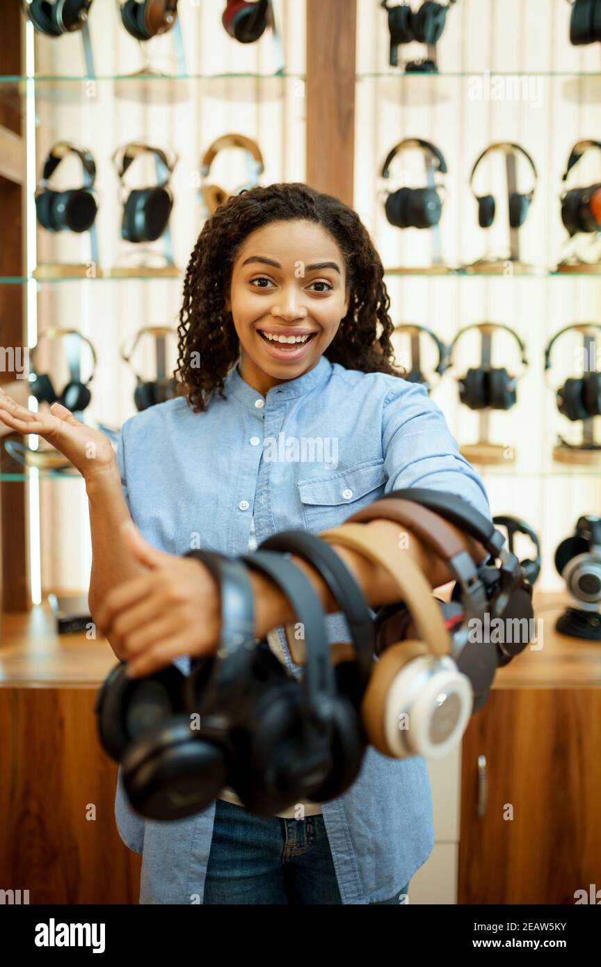 Woman shows headphones collection in audio store Stock Photo - Alamy