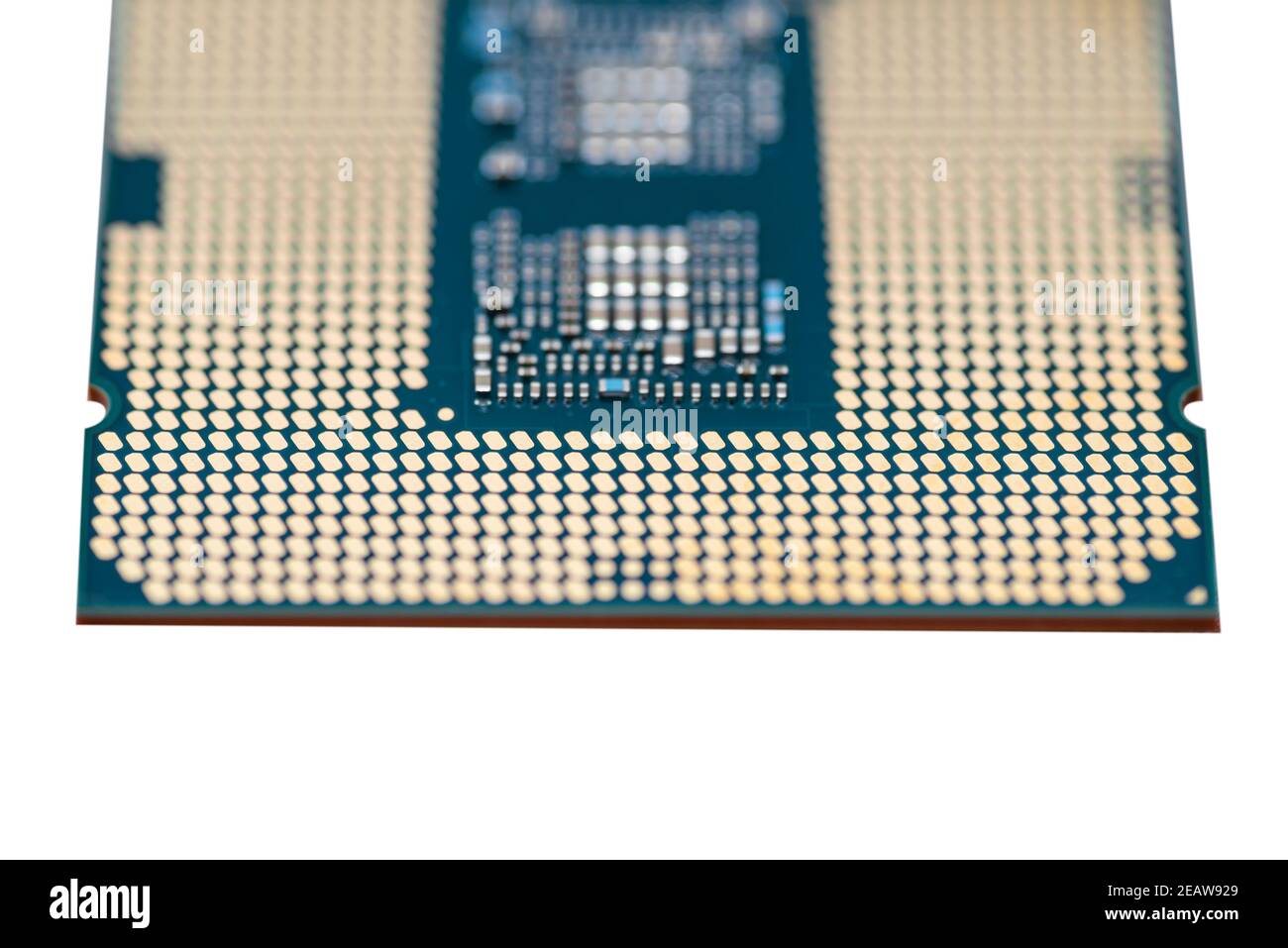 A macro photo of a modern CPU processor under the LGA 1200 socket on a green circuit board ...