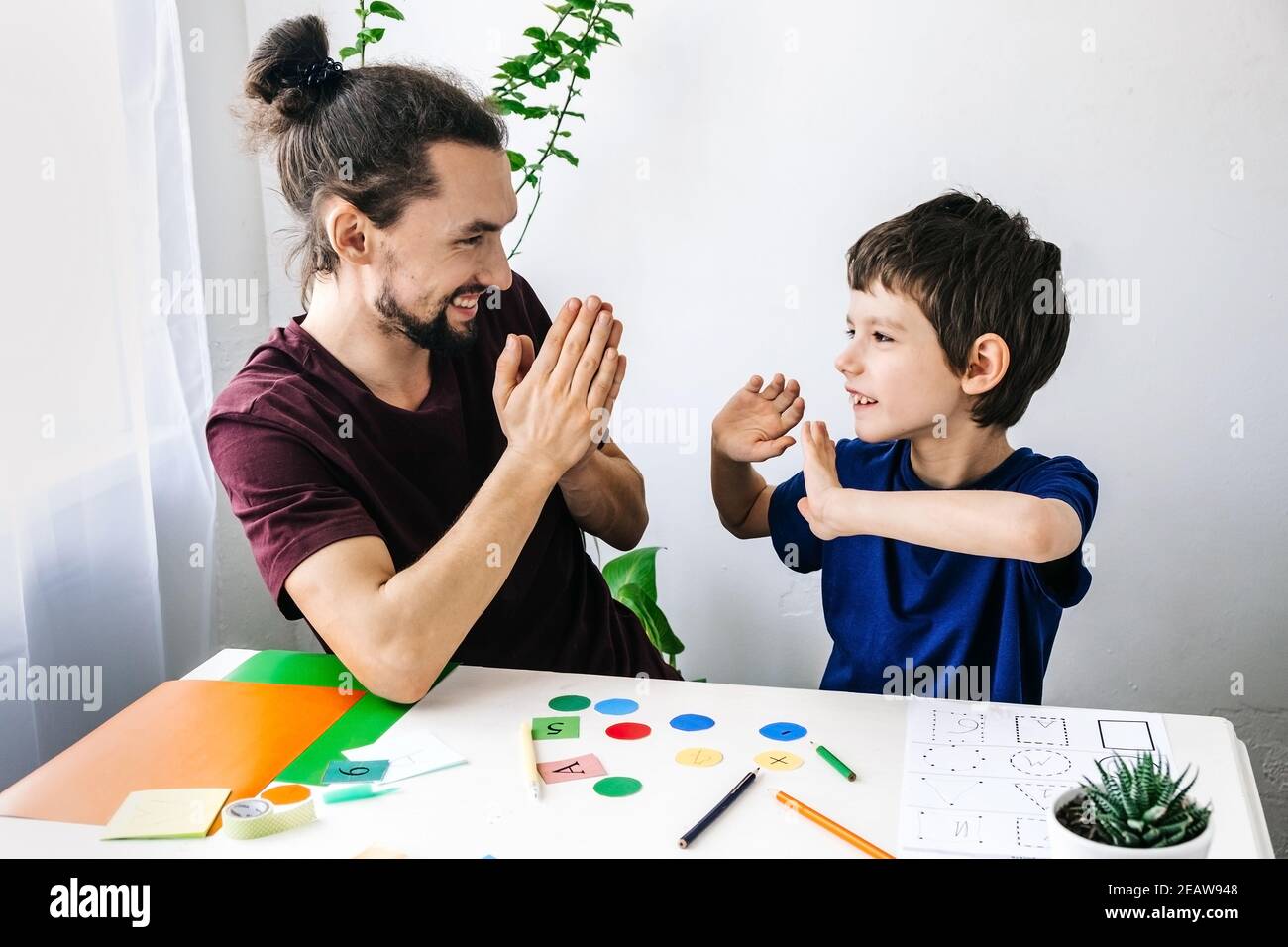 Happy autism boy during therapy with school counselor, learning and ...