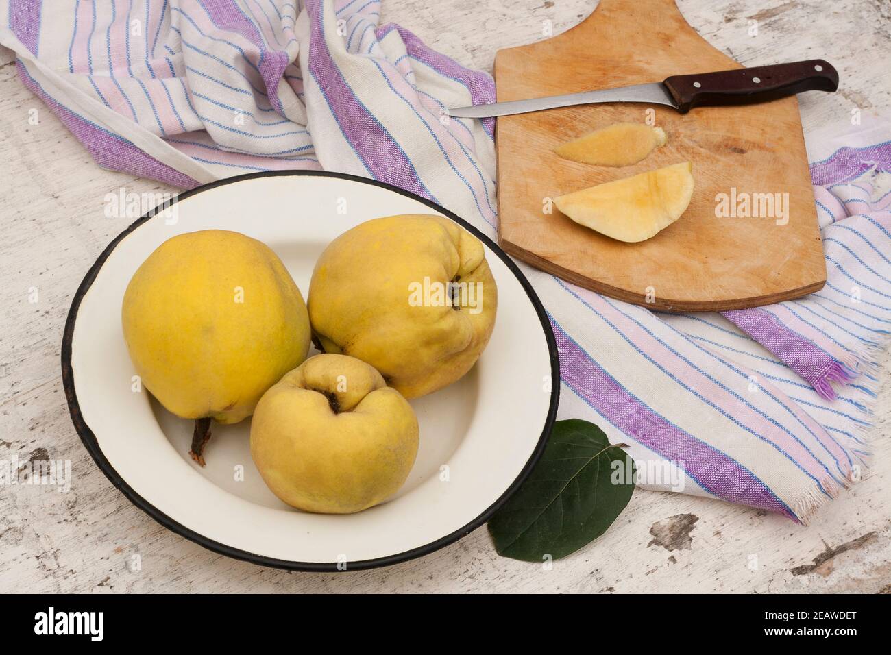 Rural still life ripe yellow quince fruits on the plate and cut fruit ...