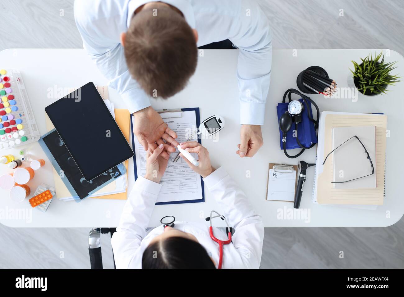 Doctor taking blood test from patients finger with lancet top view ...