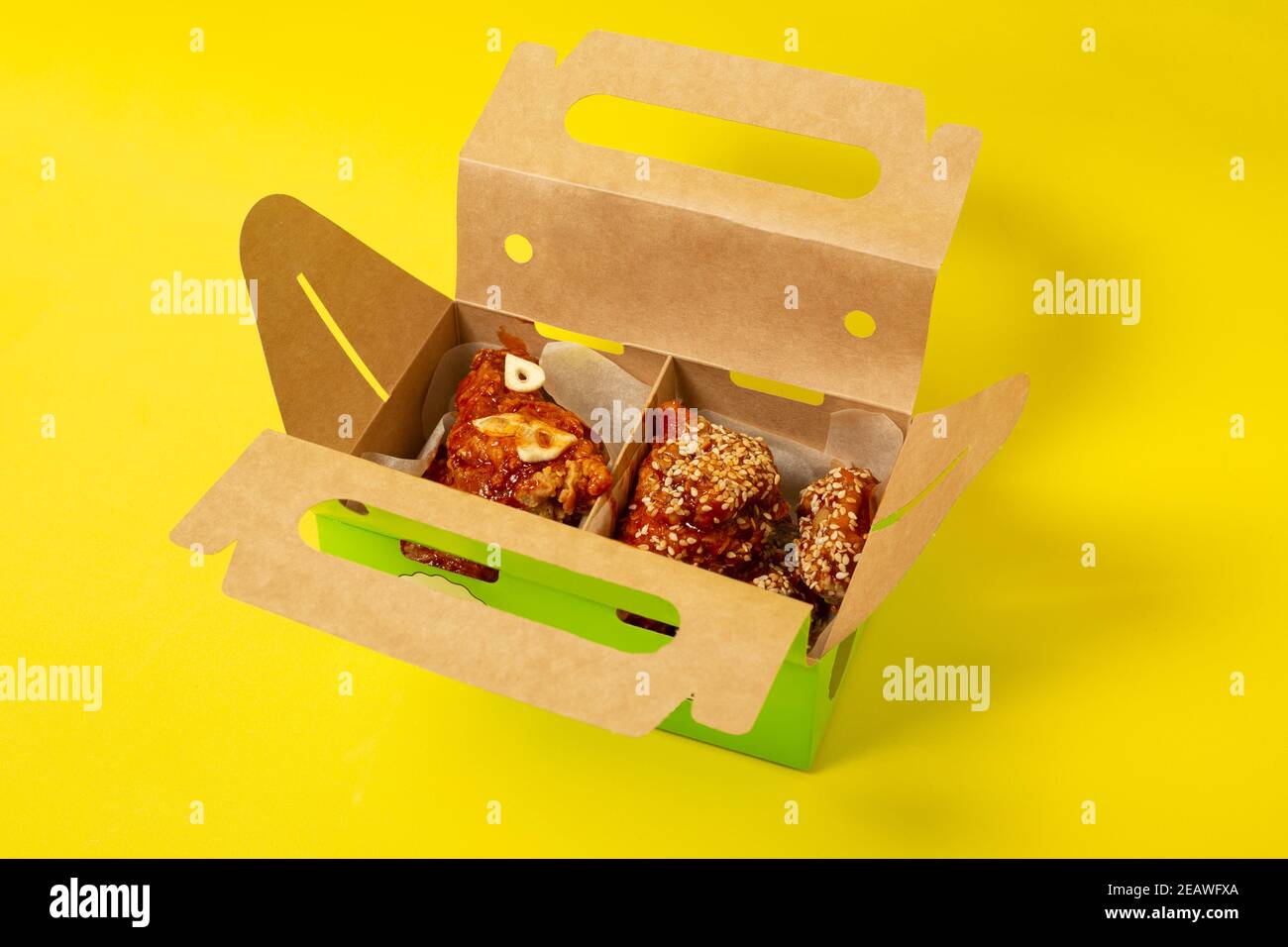 Chinese takeaway chicken with tomatoes, in a cardboard box photographed ...