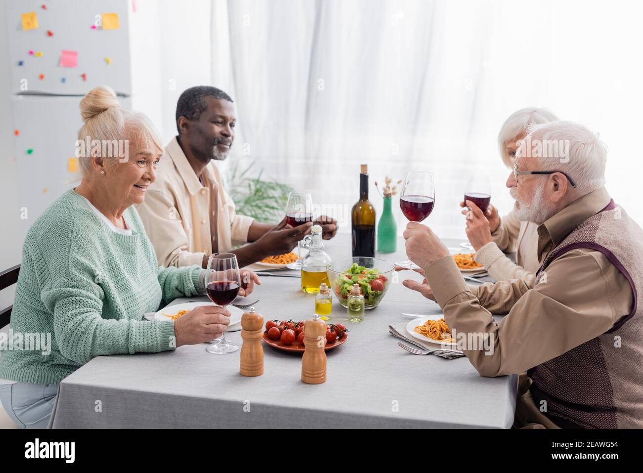 cheerful and retired multicultural friends having lunch together Stock ...